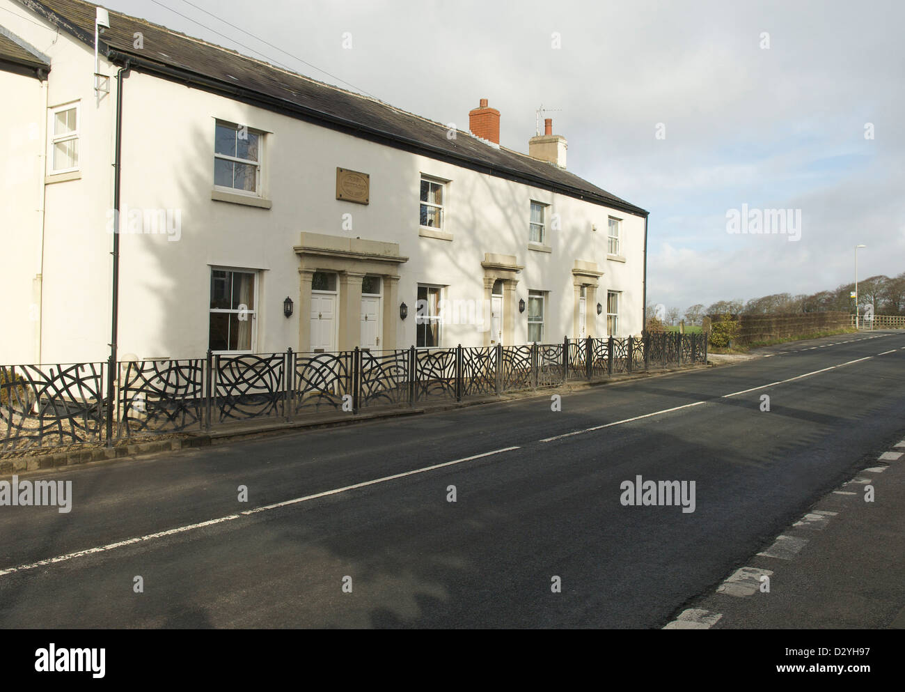 Row of white cottages on side of rural road Stock Photo - Alamy