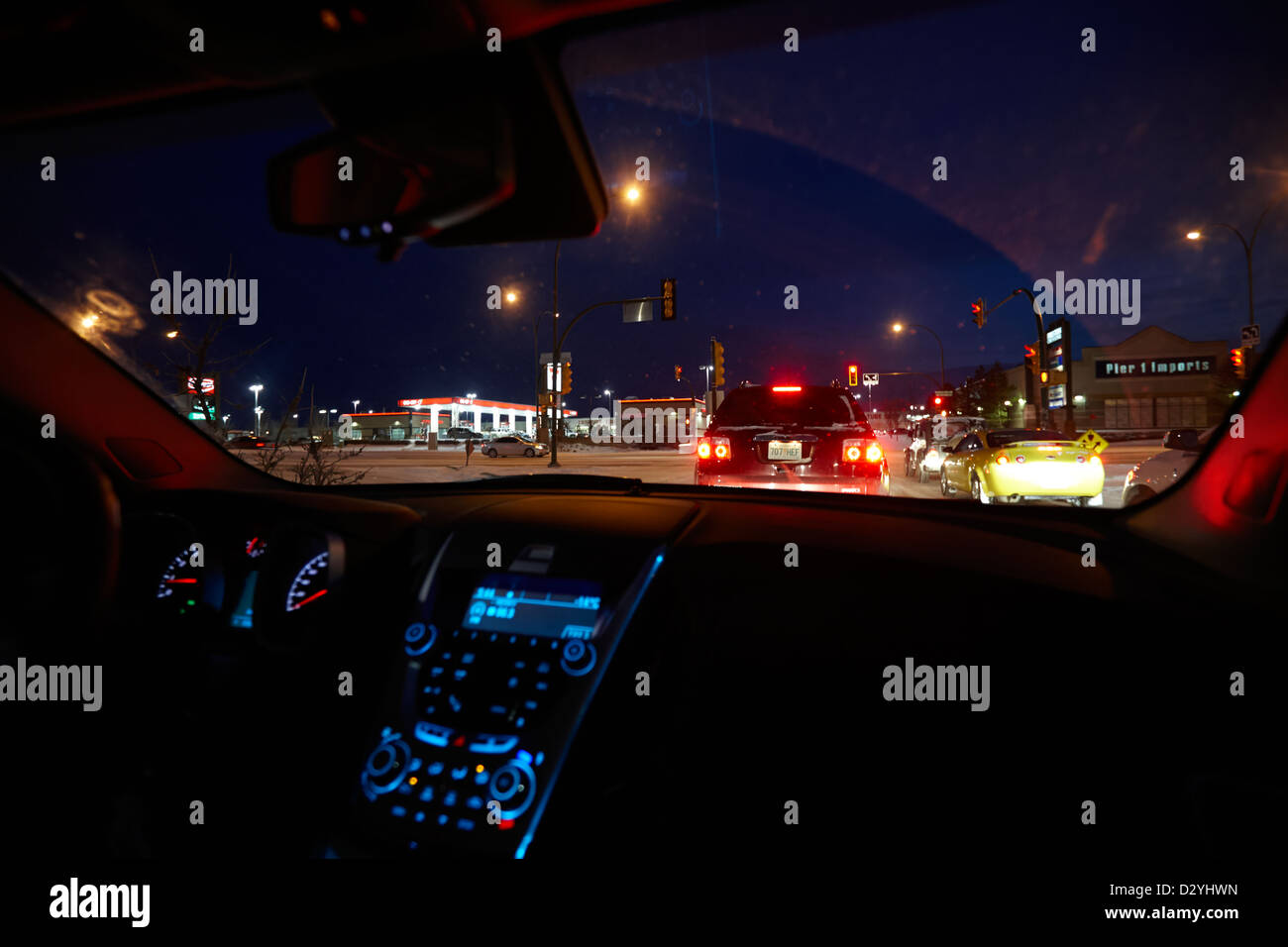 driving in traffic along cold winter frozen city road at night ...