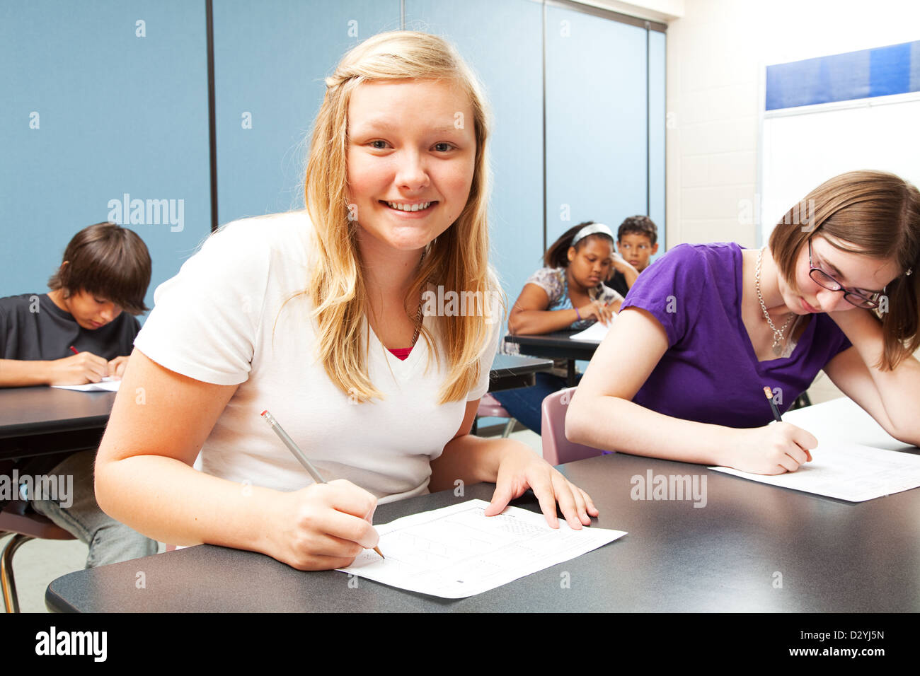 Pretty blond girl sitting in her high school class Stock Photo - Alamy