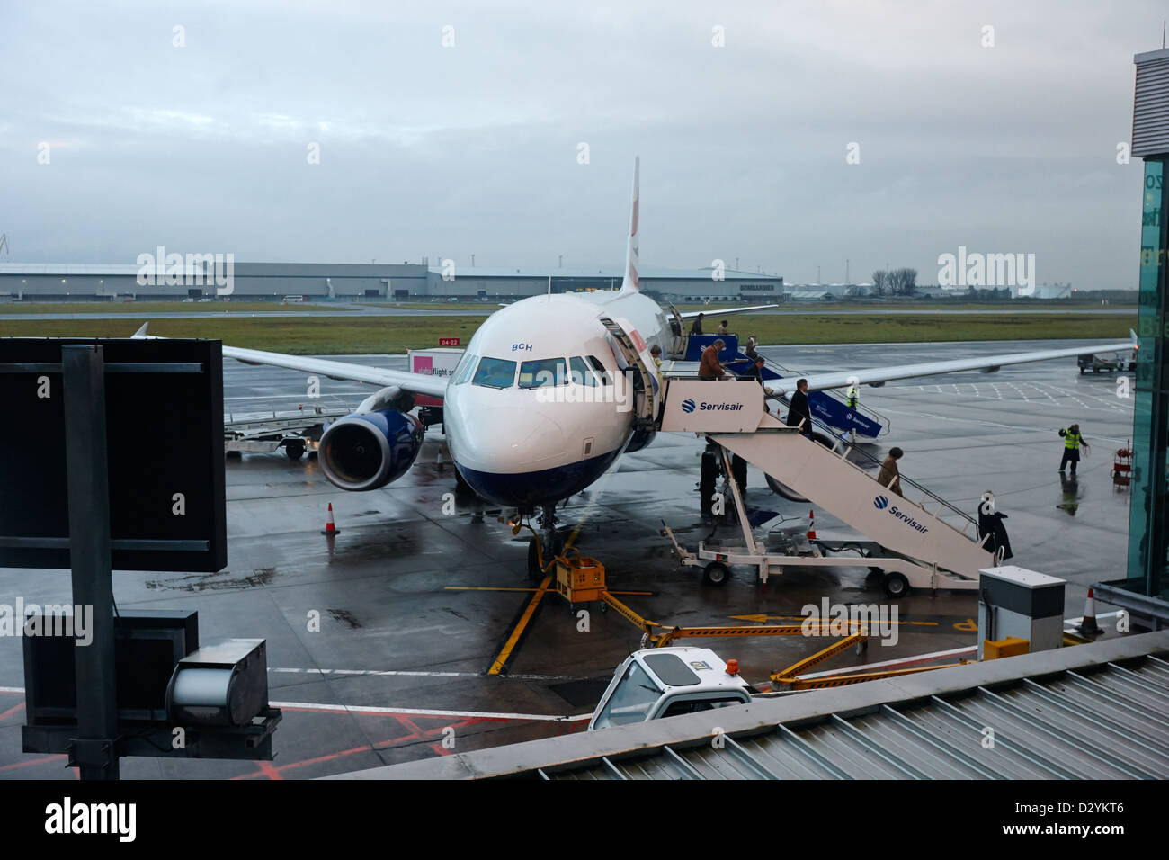 passengers disembarking british airways aircraft stand on a wet ...