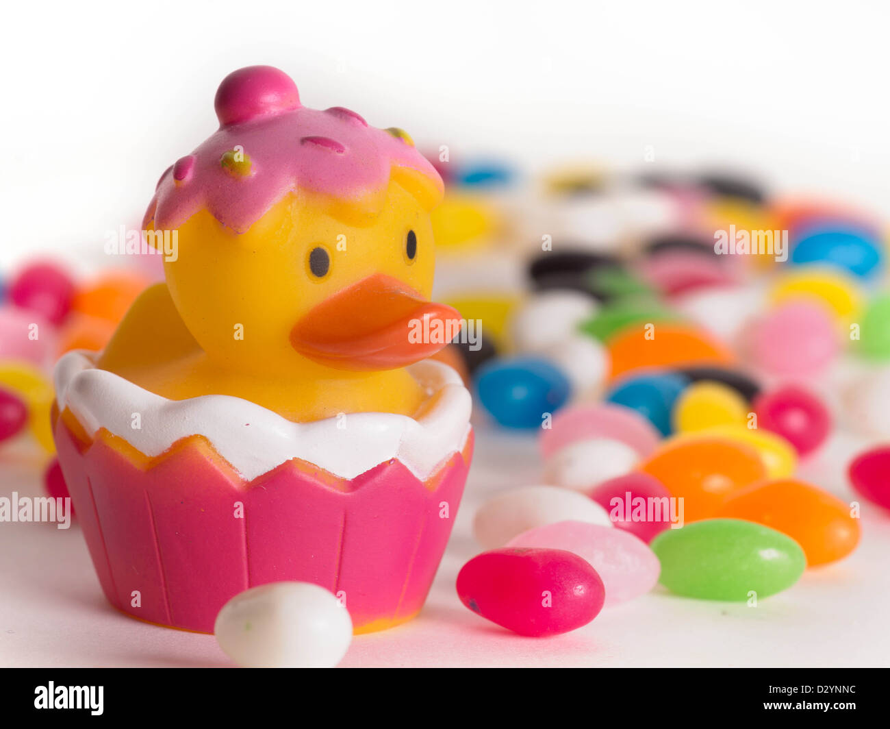 Easter rubber ducks with colorful jelly beans out of focus in the ...