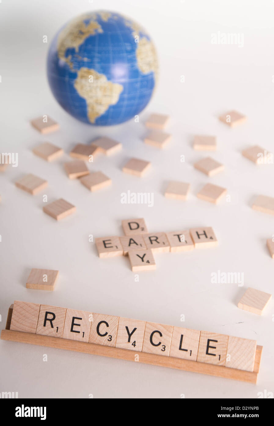 Wooden Scrabble letters spell out "Recycle" and "Earth Day" with globe ...