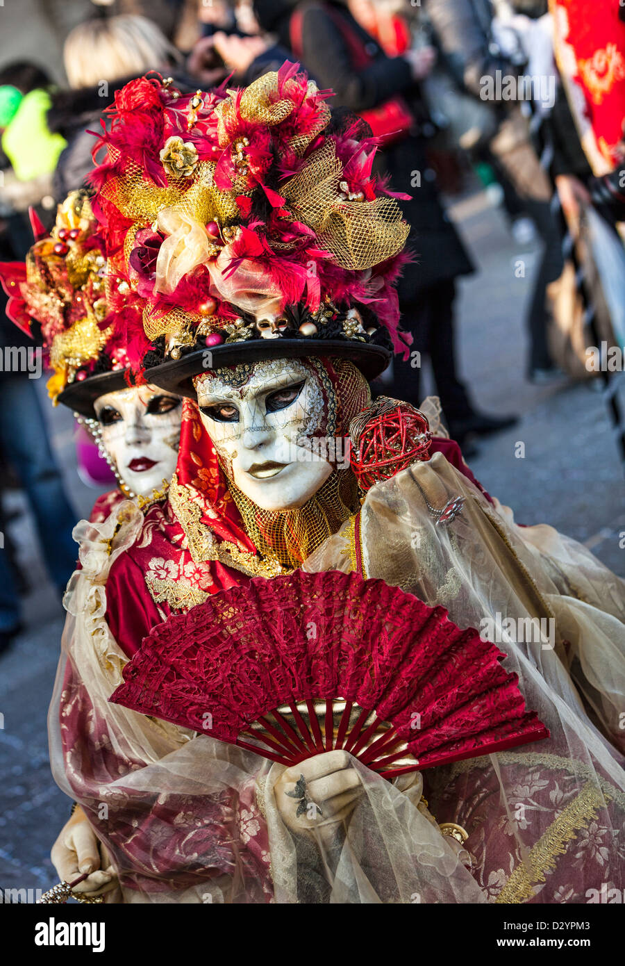 A couple wearing traditional masks and costumes perform a love scene in ...