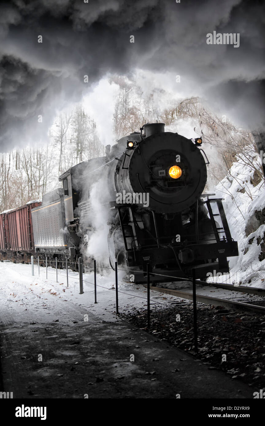 Steam train entering railroad tunnel with black locomotive smoke ...