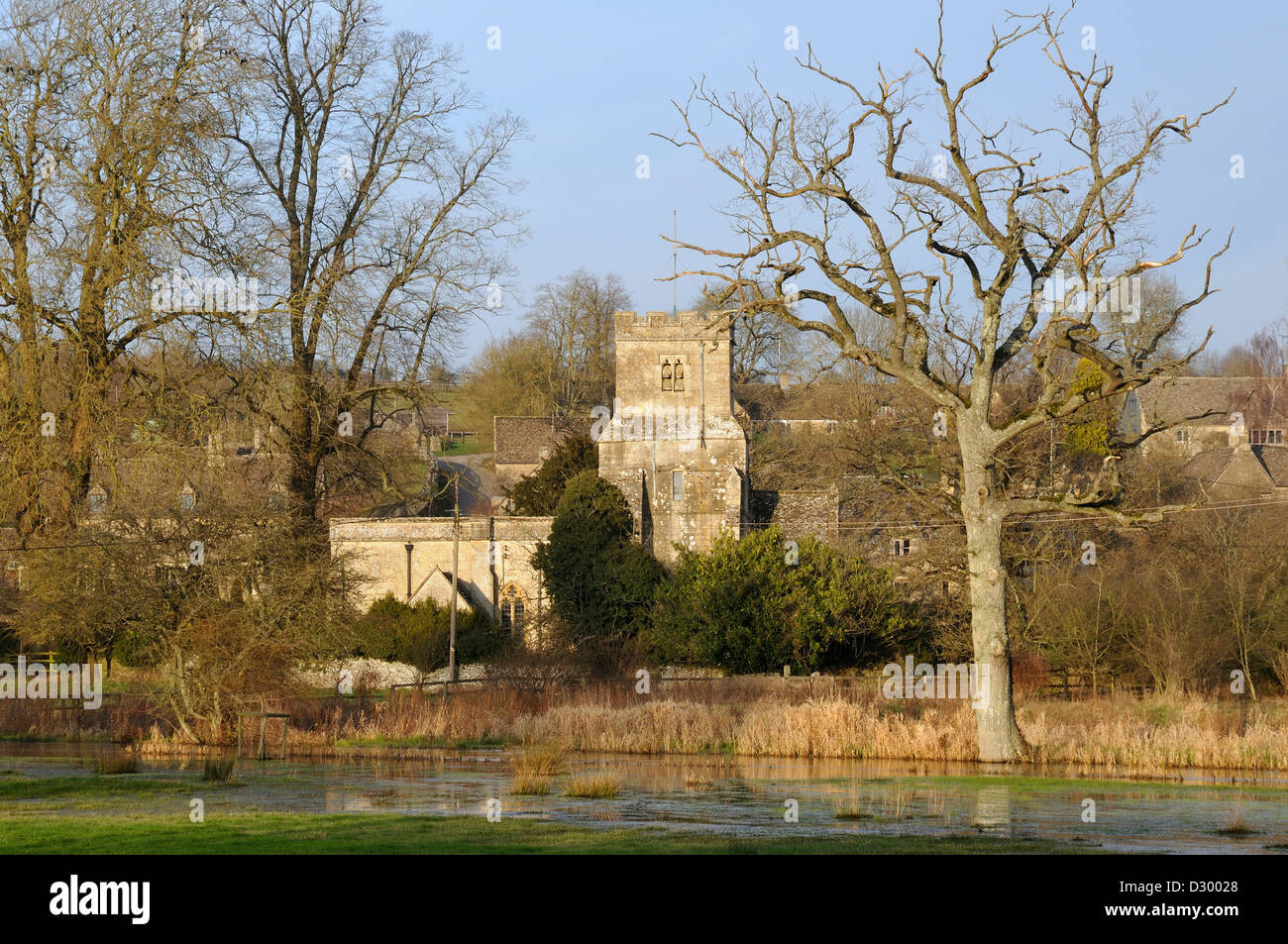 Late winter sun on St. James Norman Church and River Coln, Coln St ...