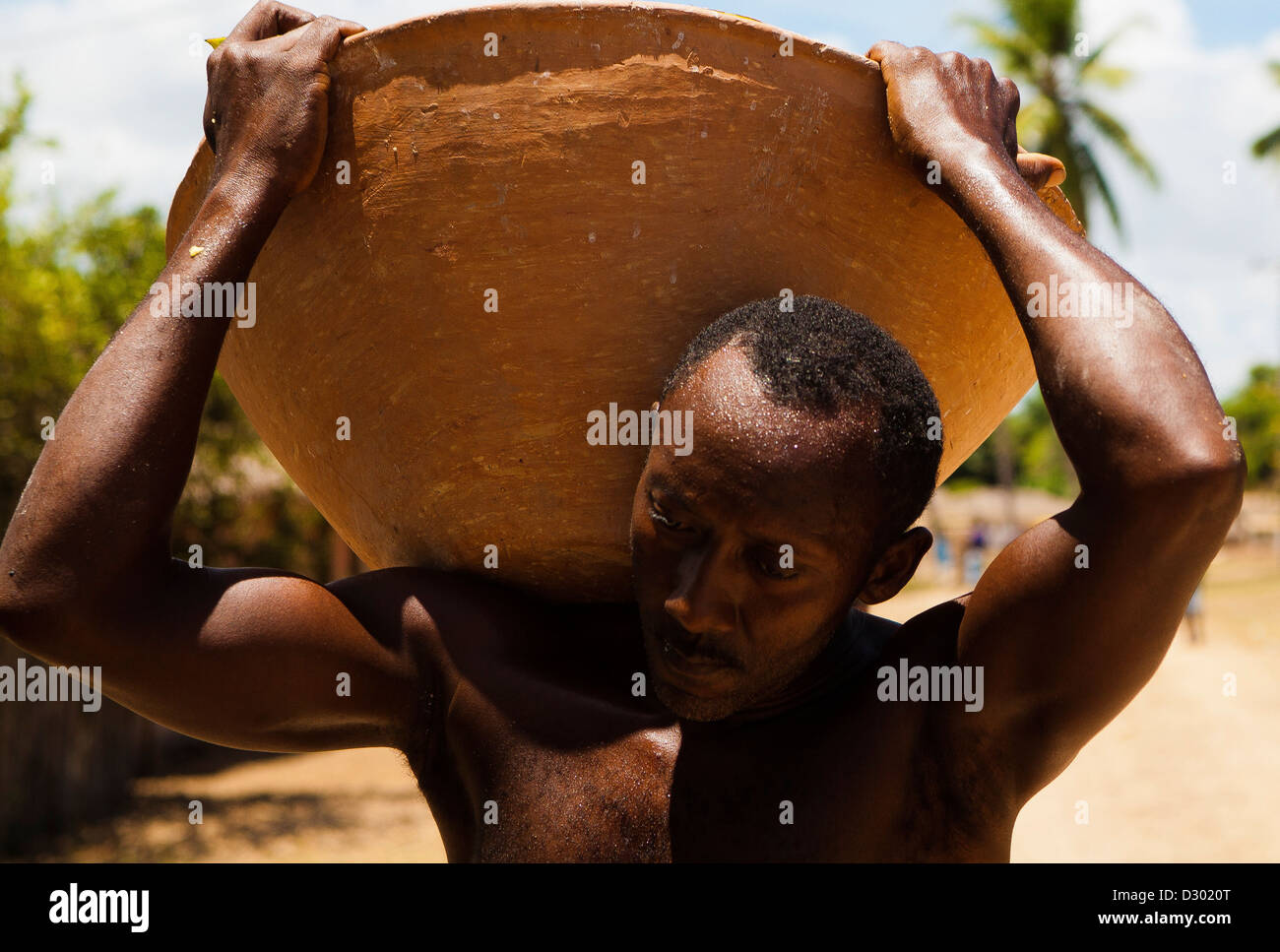 Black worker portrait, strong man carries a heavy pot at Itamatatiua ...