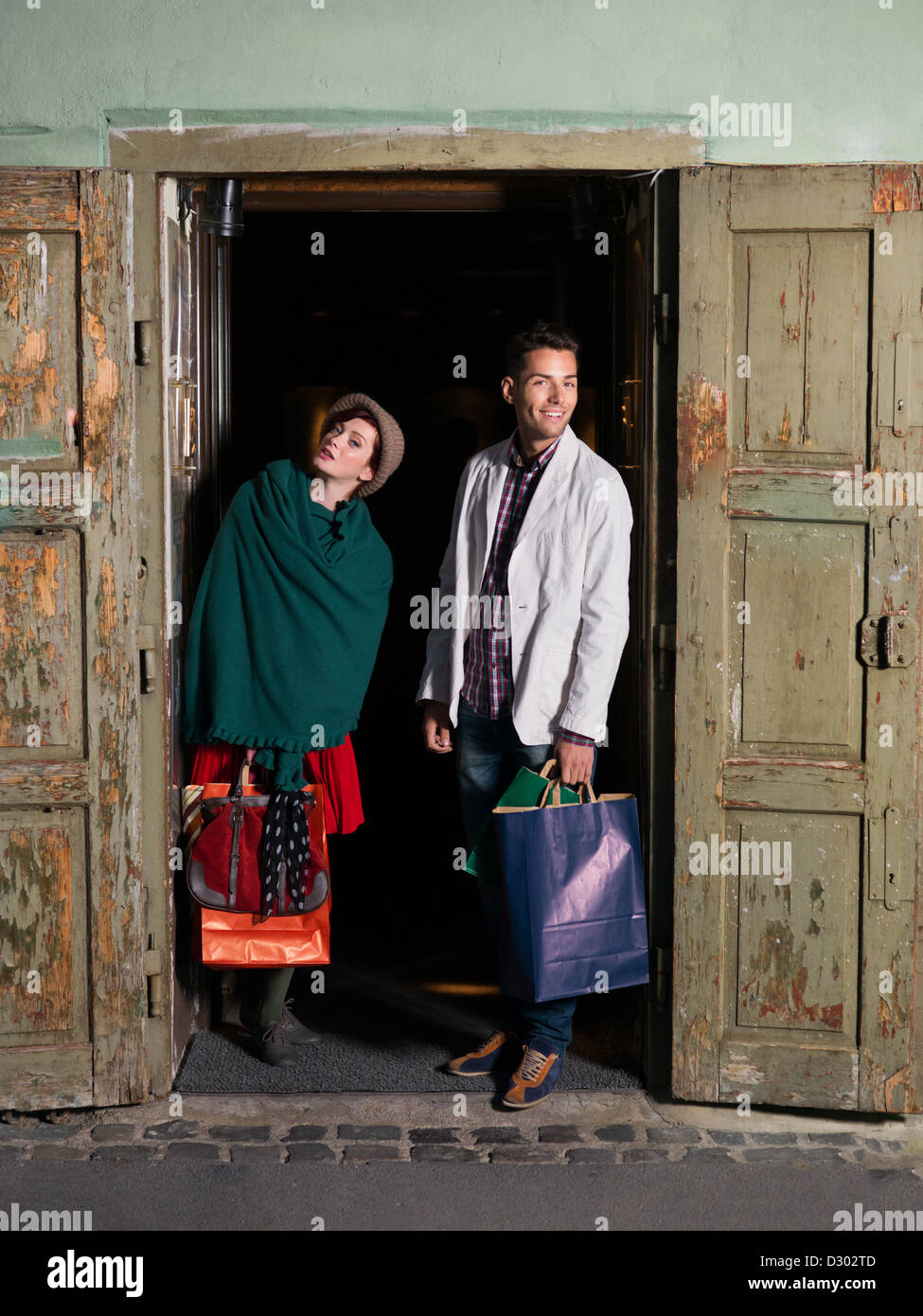 young caucasian couple standing and posing between two opened wooden ...