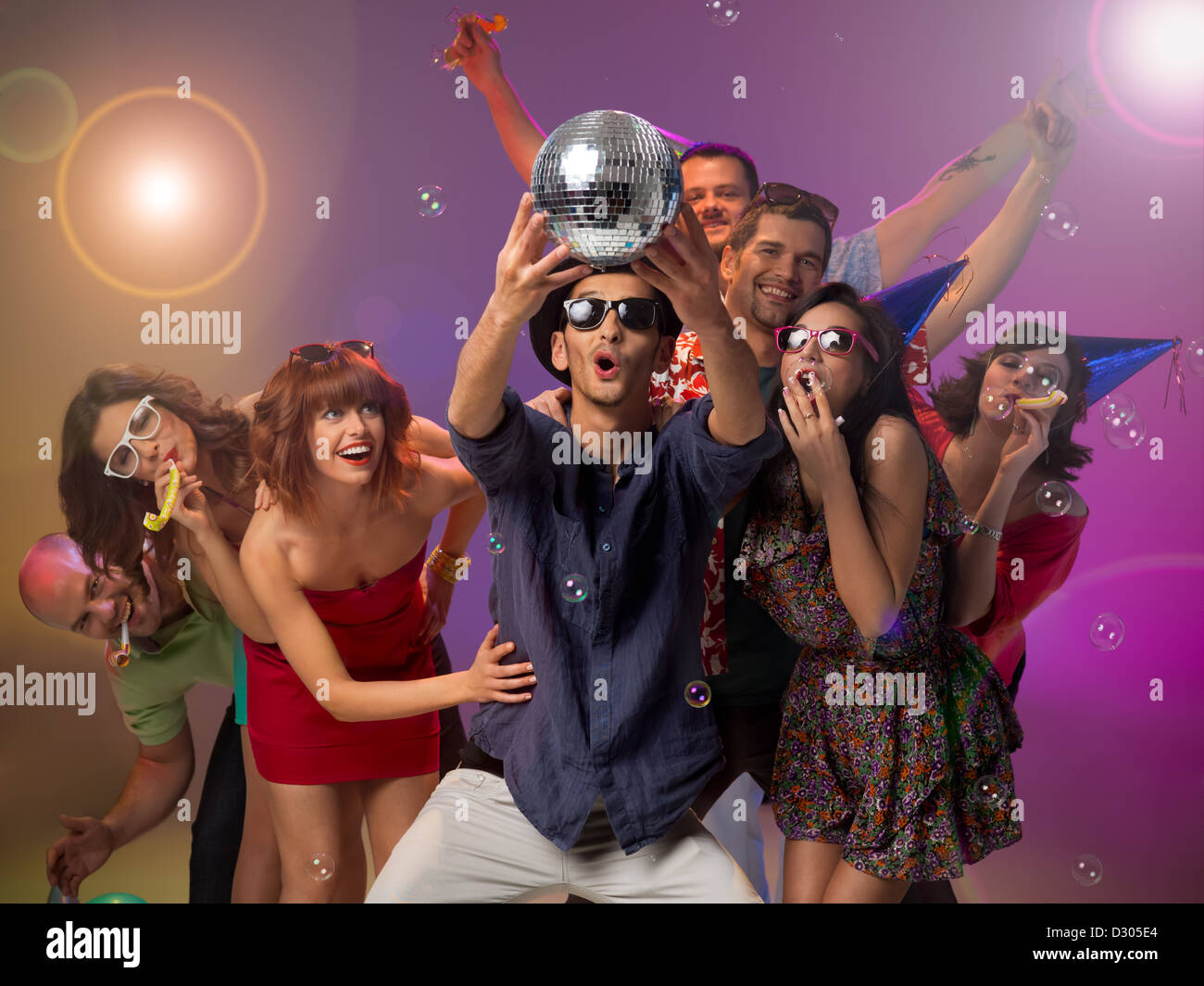 young handsome caucasian man holding a disco ball in his hands and ...
