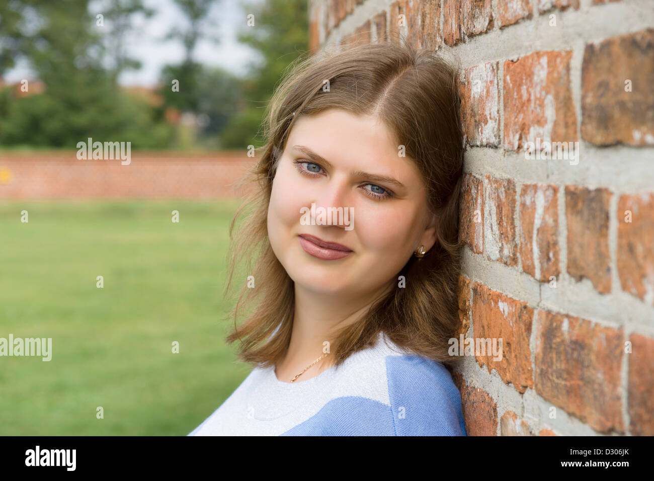 Woman against a brick wall Stock Photo - Alamy