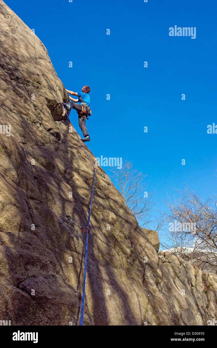 Rock climber in blue on slabby rock face Stock Photo - Alamy