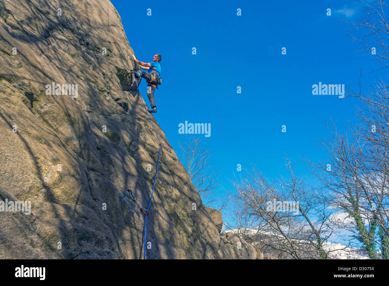 Rock climber in blue on slabby rock face Stock Photo - Alamy
