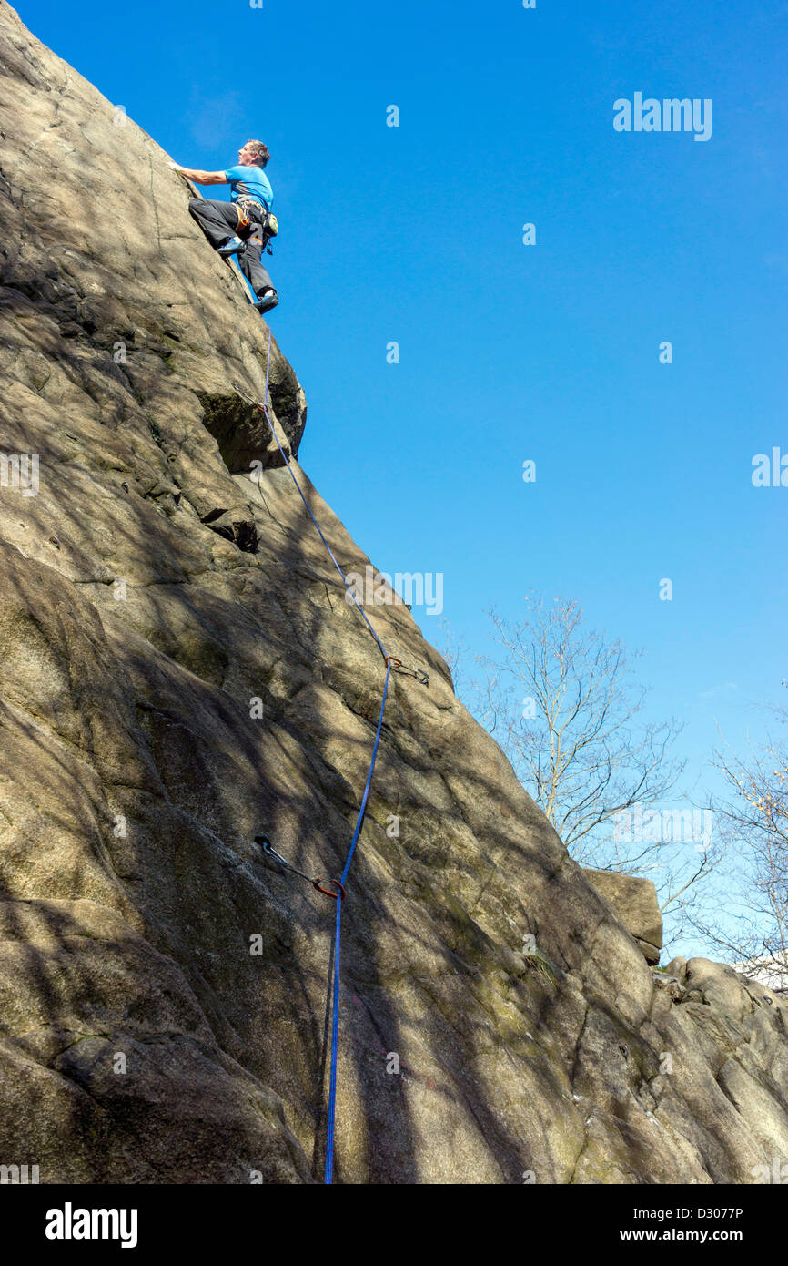 Rock climber in blue on slabby rock face Stock Photo - Alamy