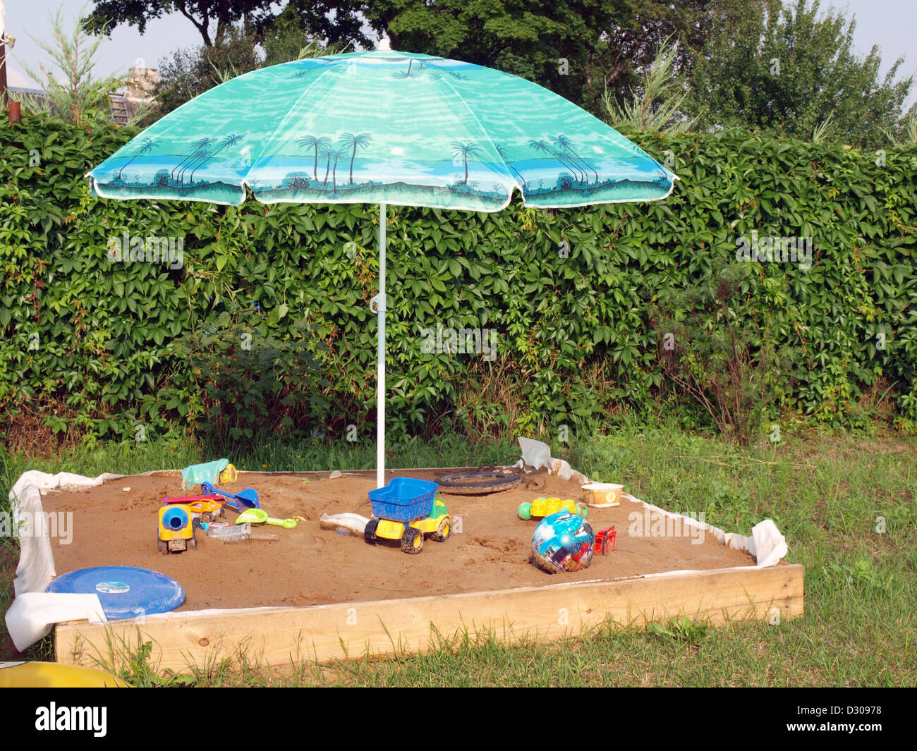 Homemade baby sand box with toys and umbrella Stock Photo - Alamy