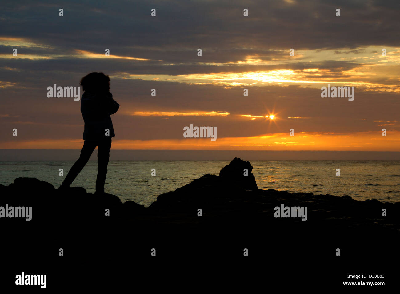 Boy Watching Sunset over Pacific Ocean Stock Photo - Alamy