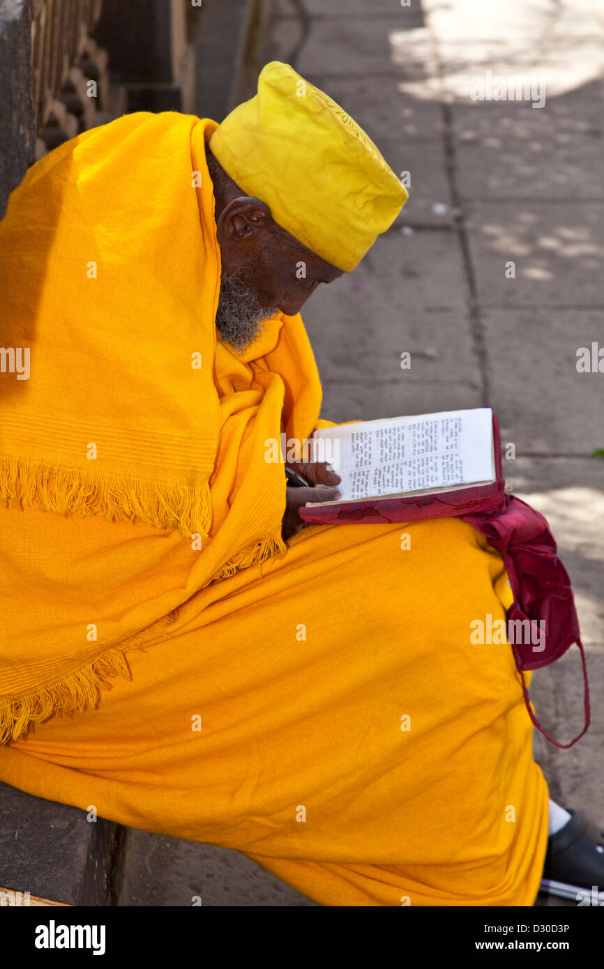 A Priest sits reading from the scriptures outside The Holy Trinity ...