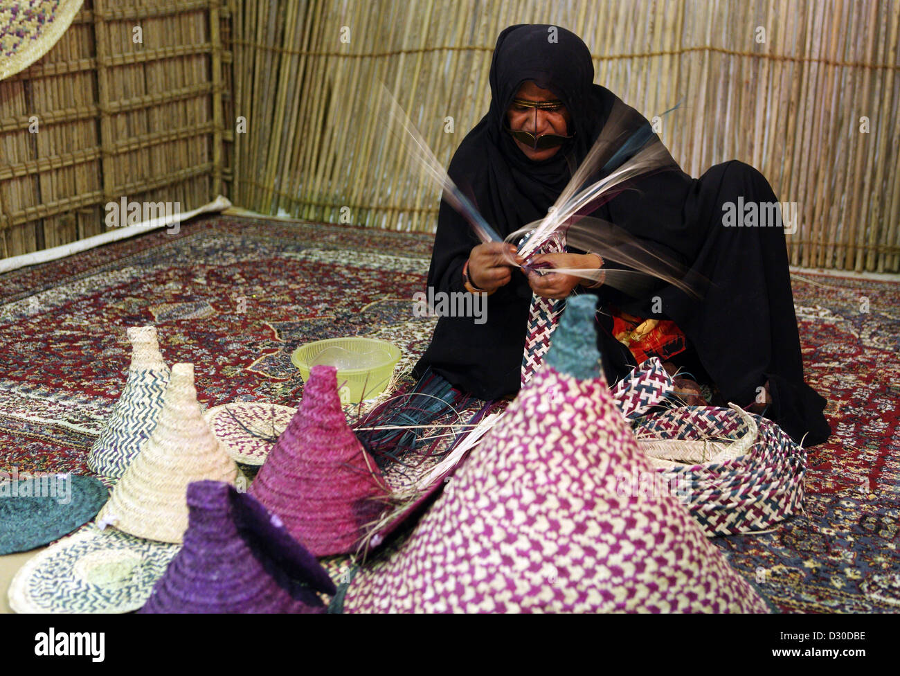 Dubai, United Arab Emirates, woman in national dress with raffia weaves ...