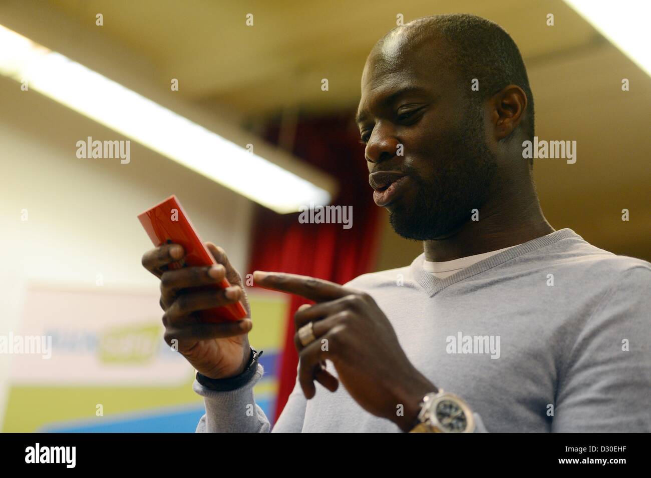 Soccer player Hans Sarpei looks at his smartphone at the Berlin ...