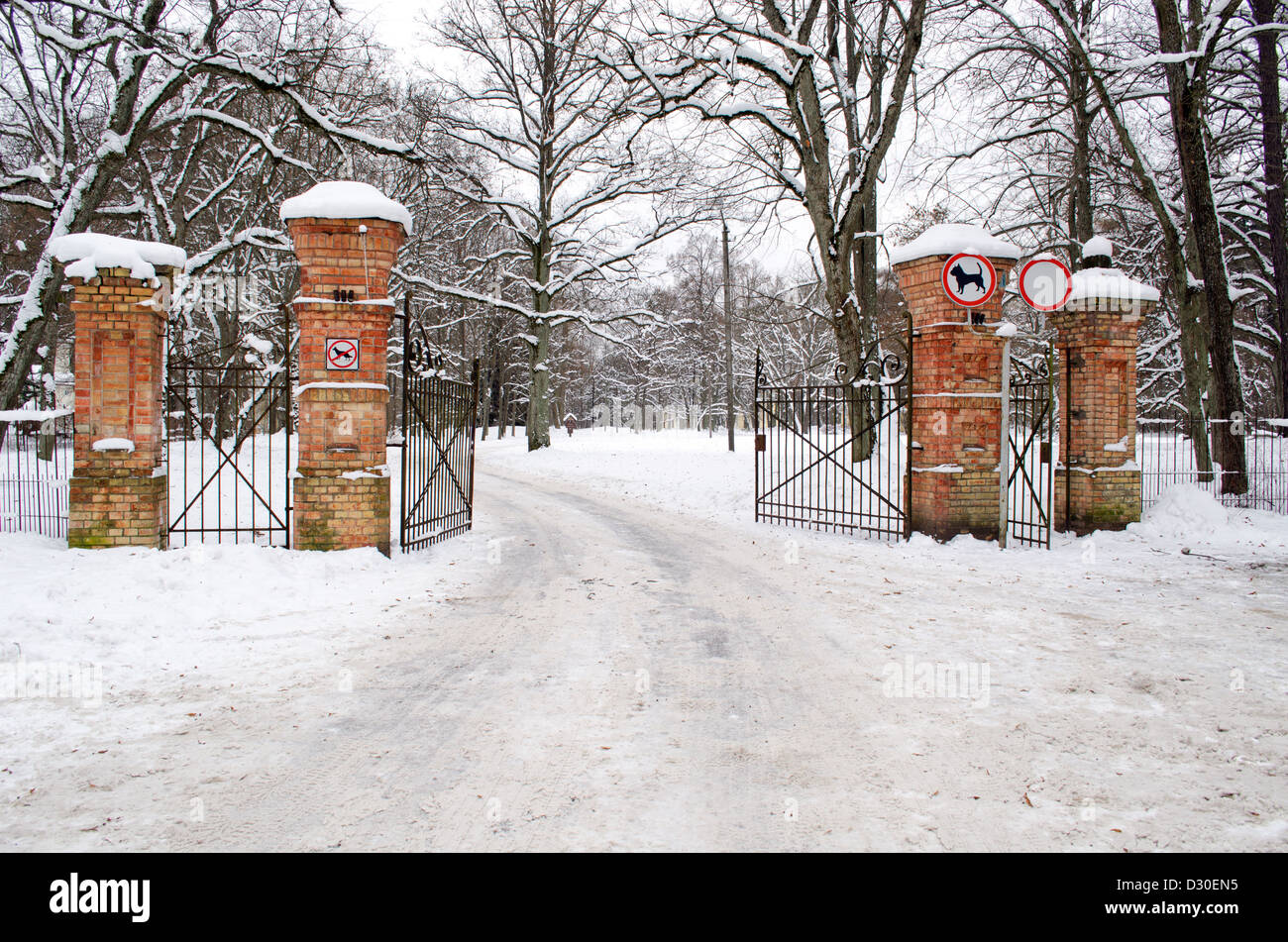 ancient open red brick gates to park and dog car prohibition signs in ...