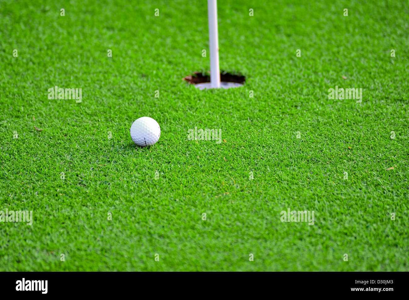 Golf ball and golf hole on the green grass Stock Photo - Alamy