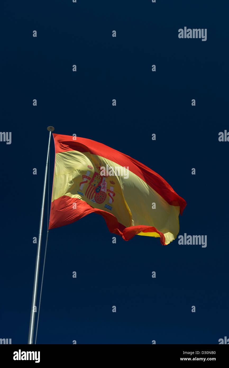 LARGE SPANISH FLAG FLYING ON FLAG POLE WITH BLUE SKY BACKGROUND Stock ...