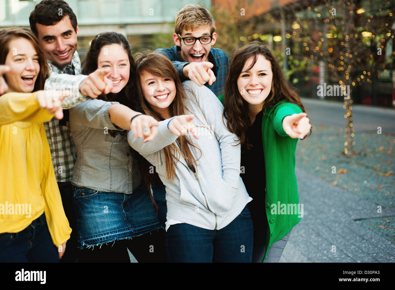Group of friends outside pointing and smiling Stock Photo - Alamy