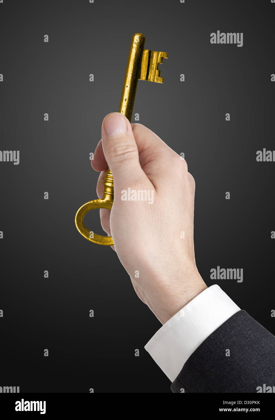 Hand holding golden key to success over black background Stock Photo ...