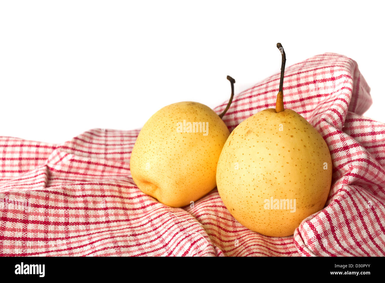 Tasty yellow pear fruit on a kitchen table with red and white checkered ...
