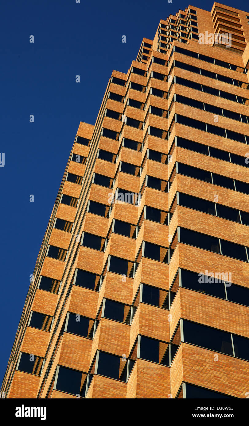 Close up vertical view of modern tan office building on a clear day ...