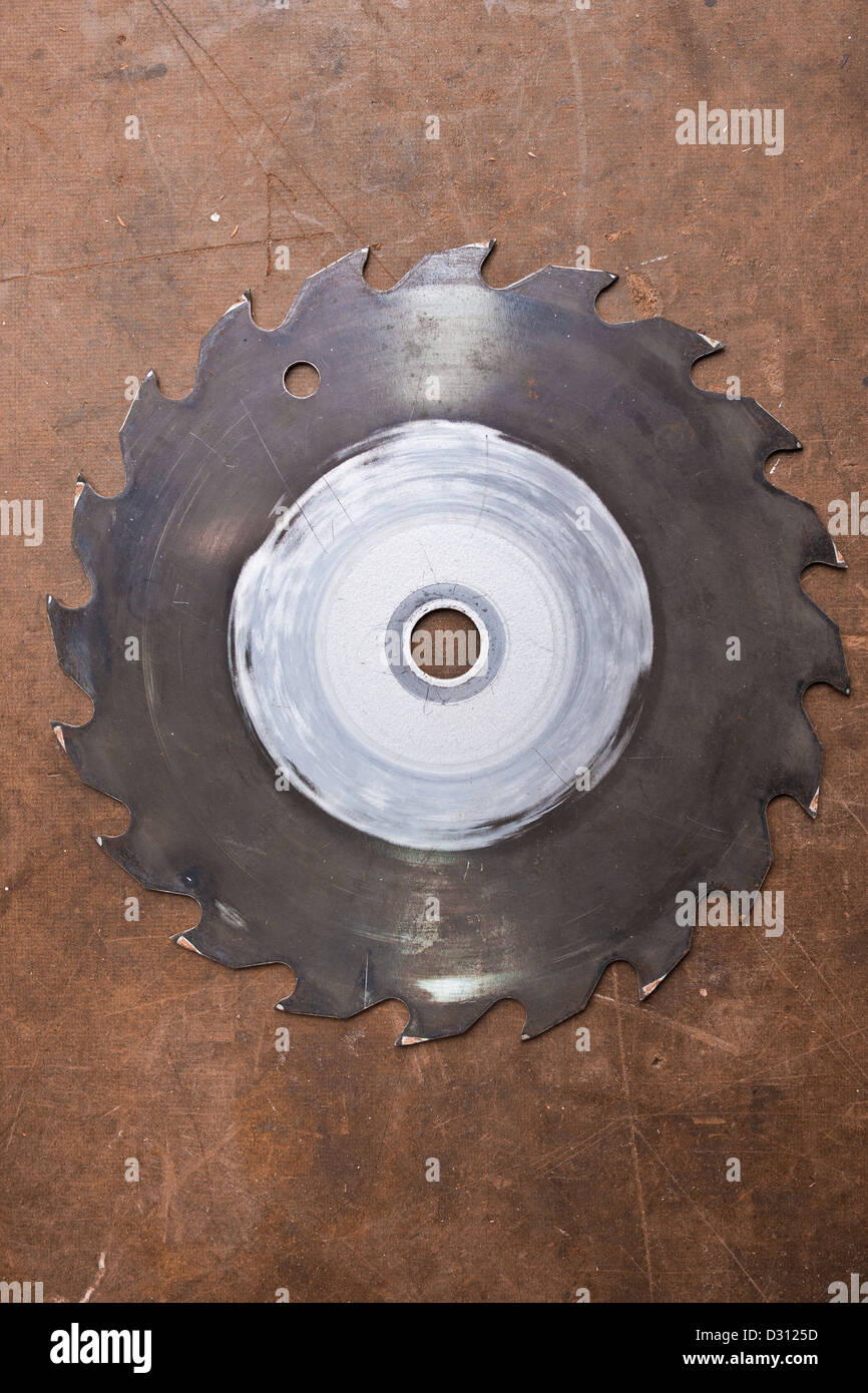 A metal, rusty, circular saw blade on a brown table top Stock Photo - Alamy