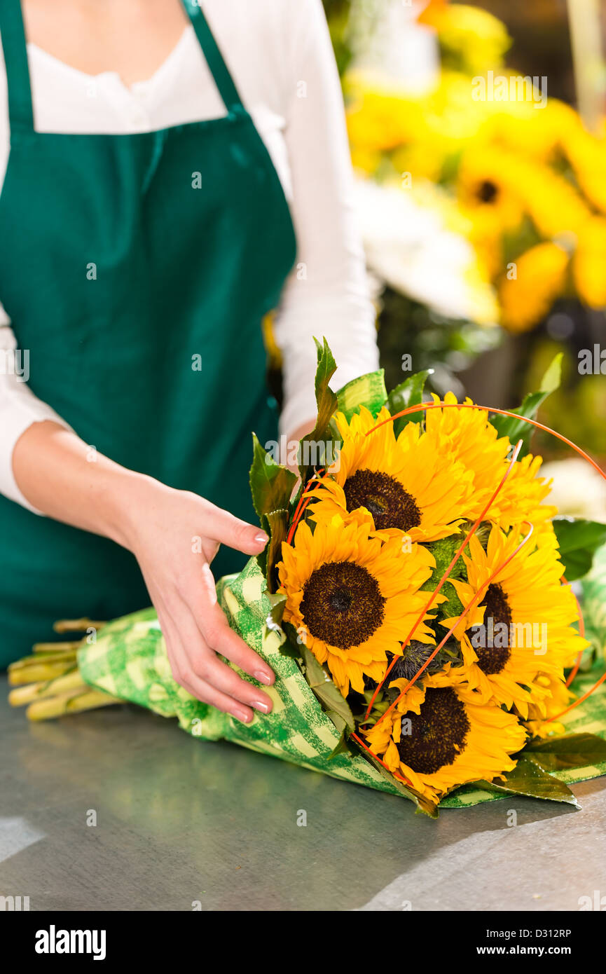 Florist preparing sunflowers bouquet flower shop assistant yellow hands ...