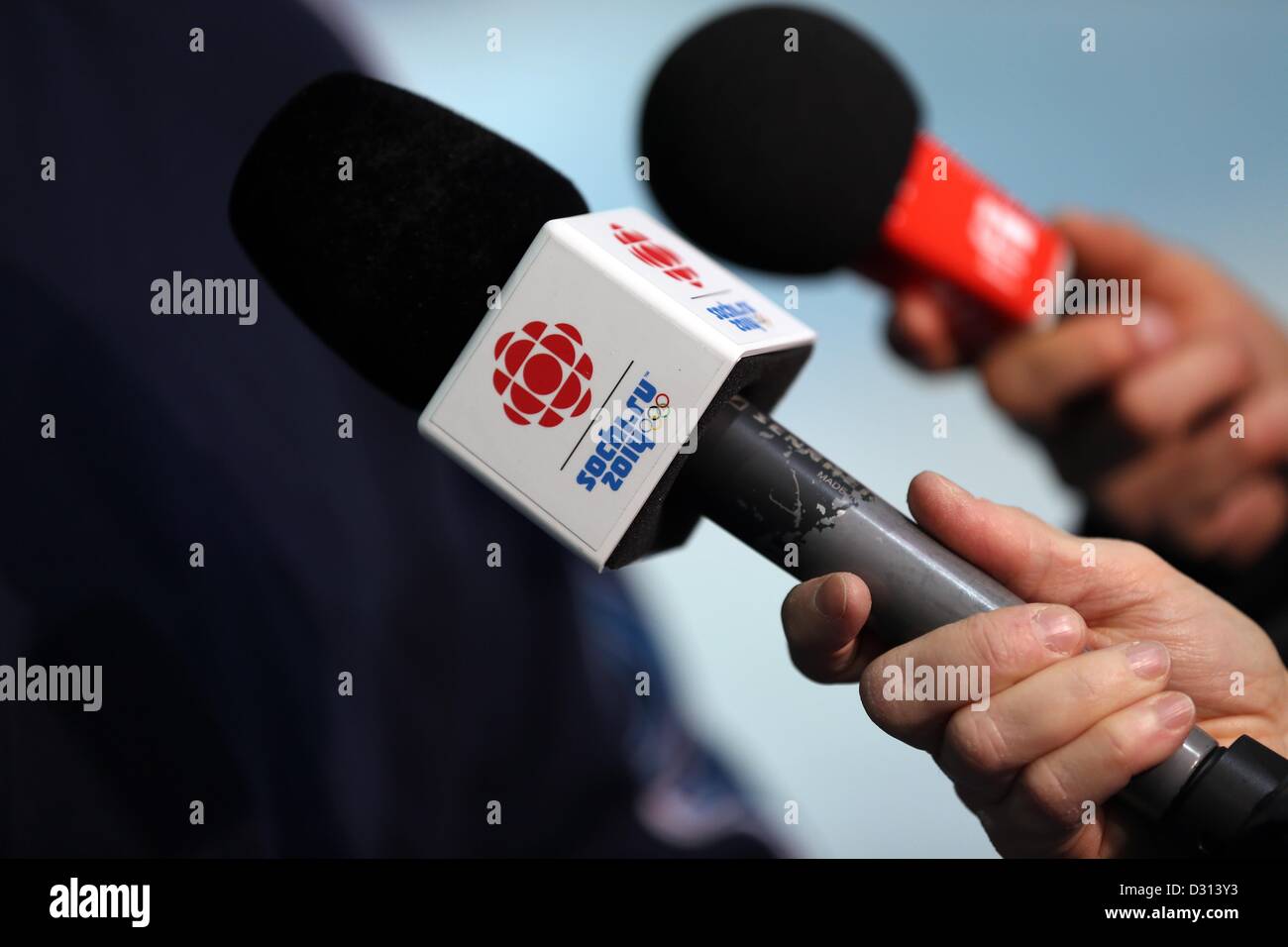 A journalist holds a microphone with the 'Sochi 2014' logo at the ...