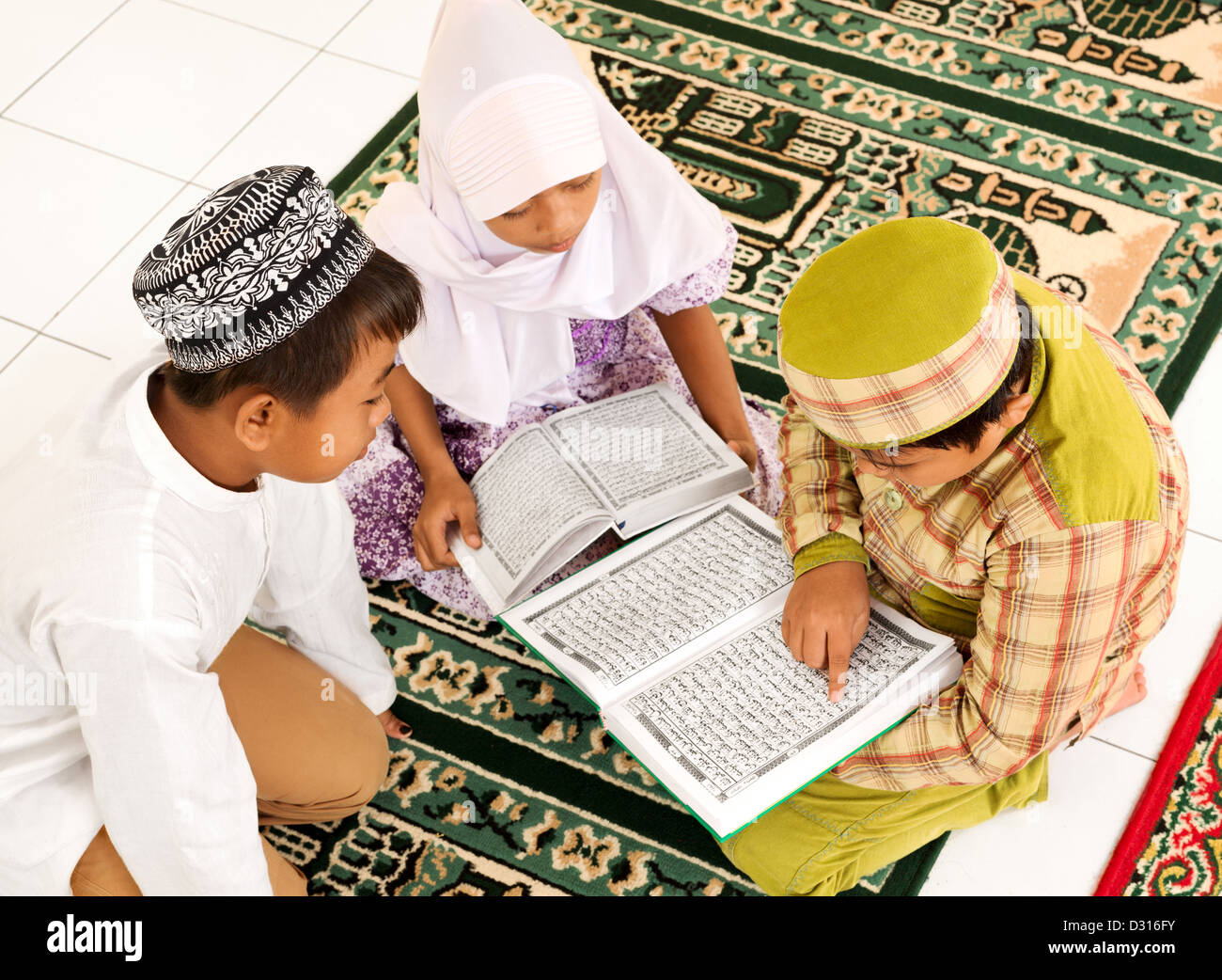 Smal group of children reading Koran Stock Photo - Alamy