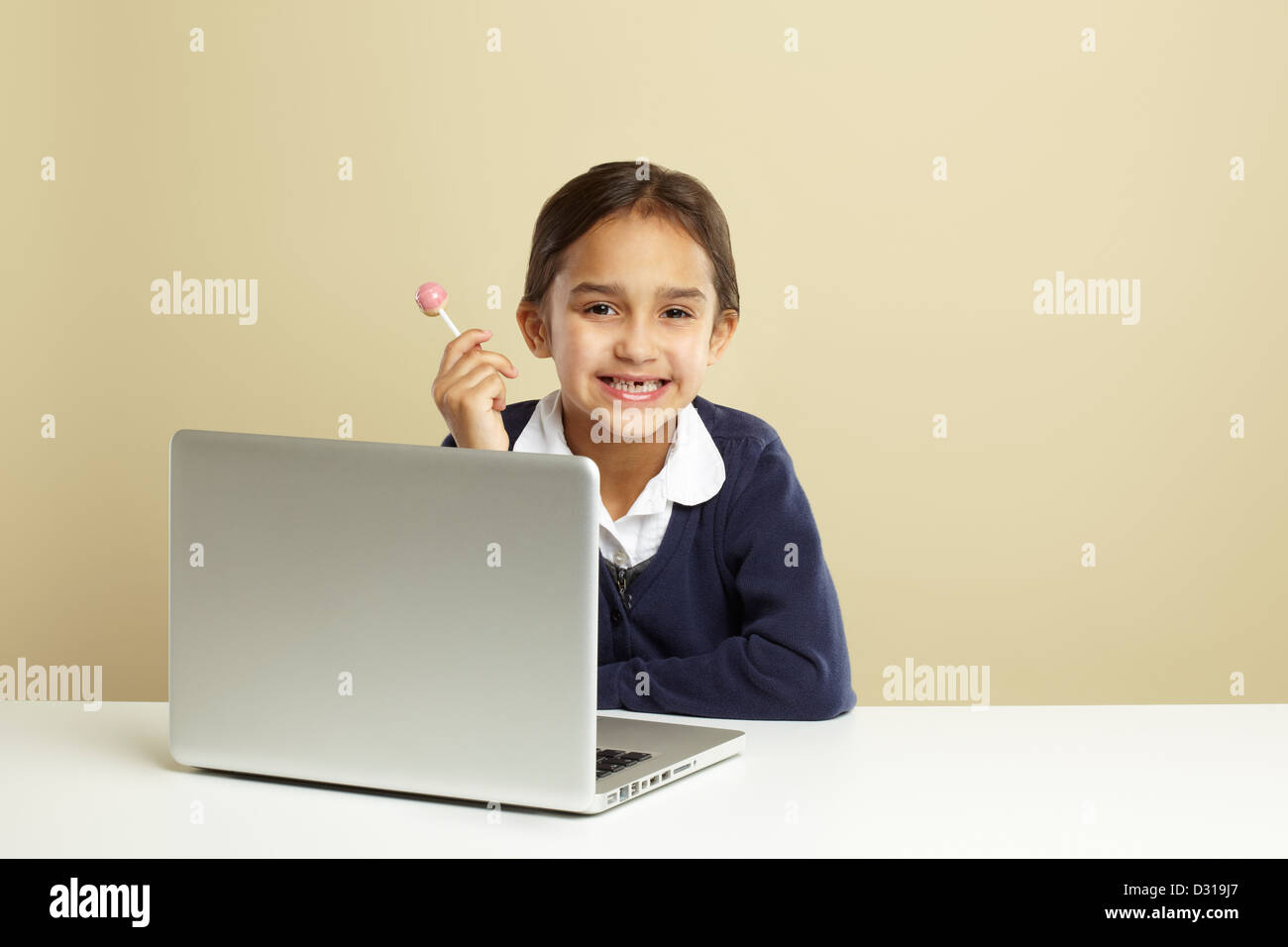 Young girl using laptop on white desk Stock Photo - Alamy