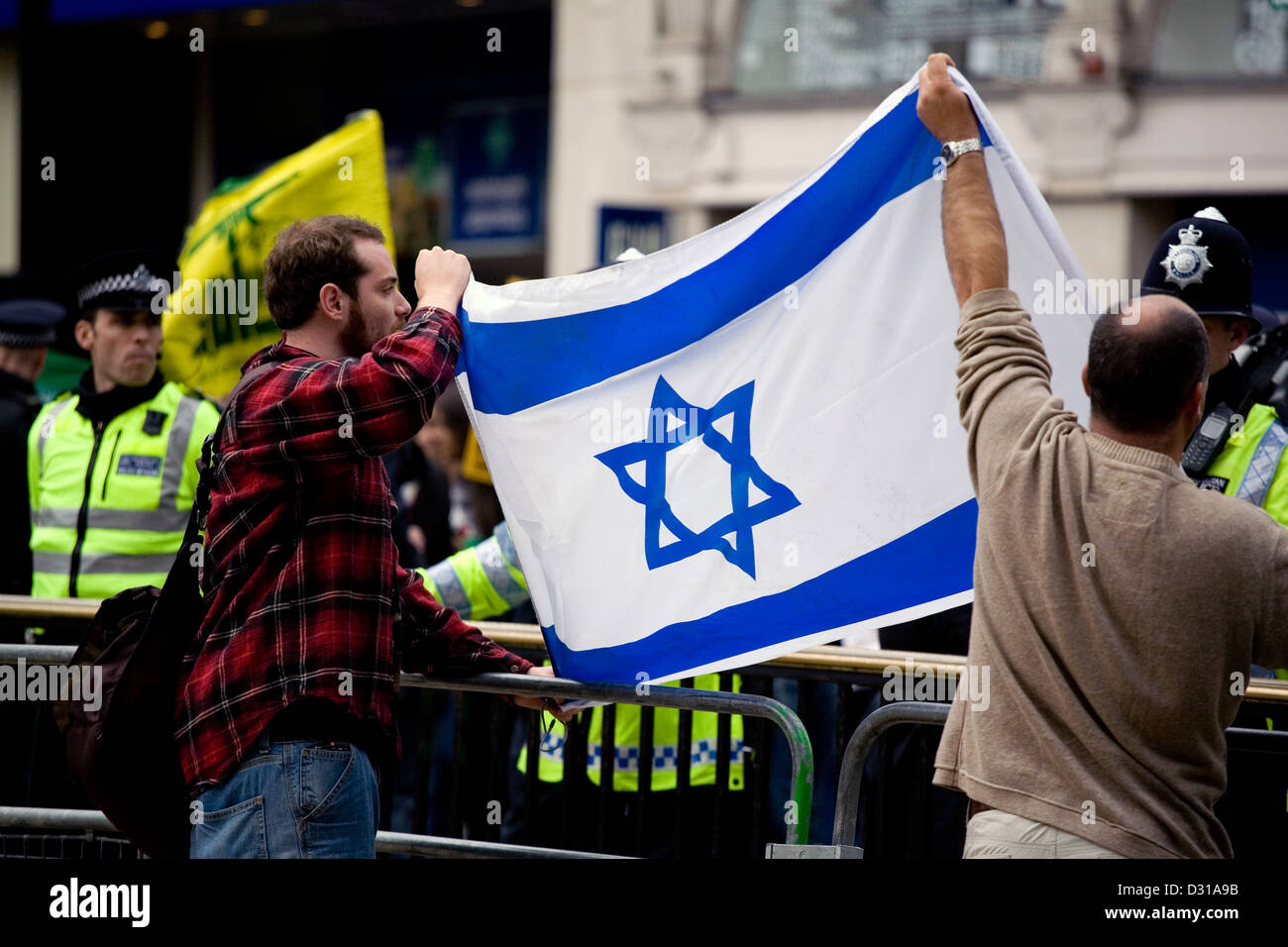 Pro Israel protesters hold the Israeli flag at an anti Israel protest ...