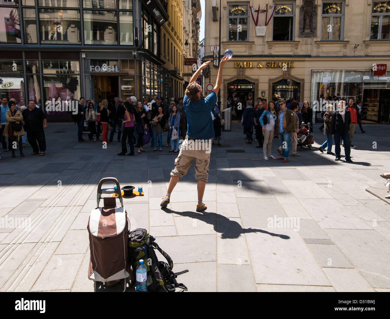 a comedian playing with a glass ball in front of group of people in ...
