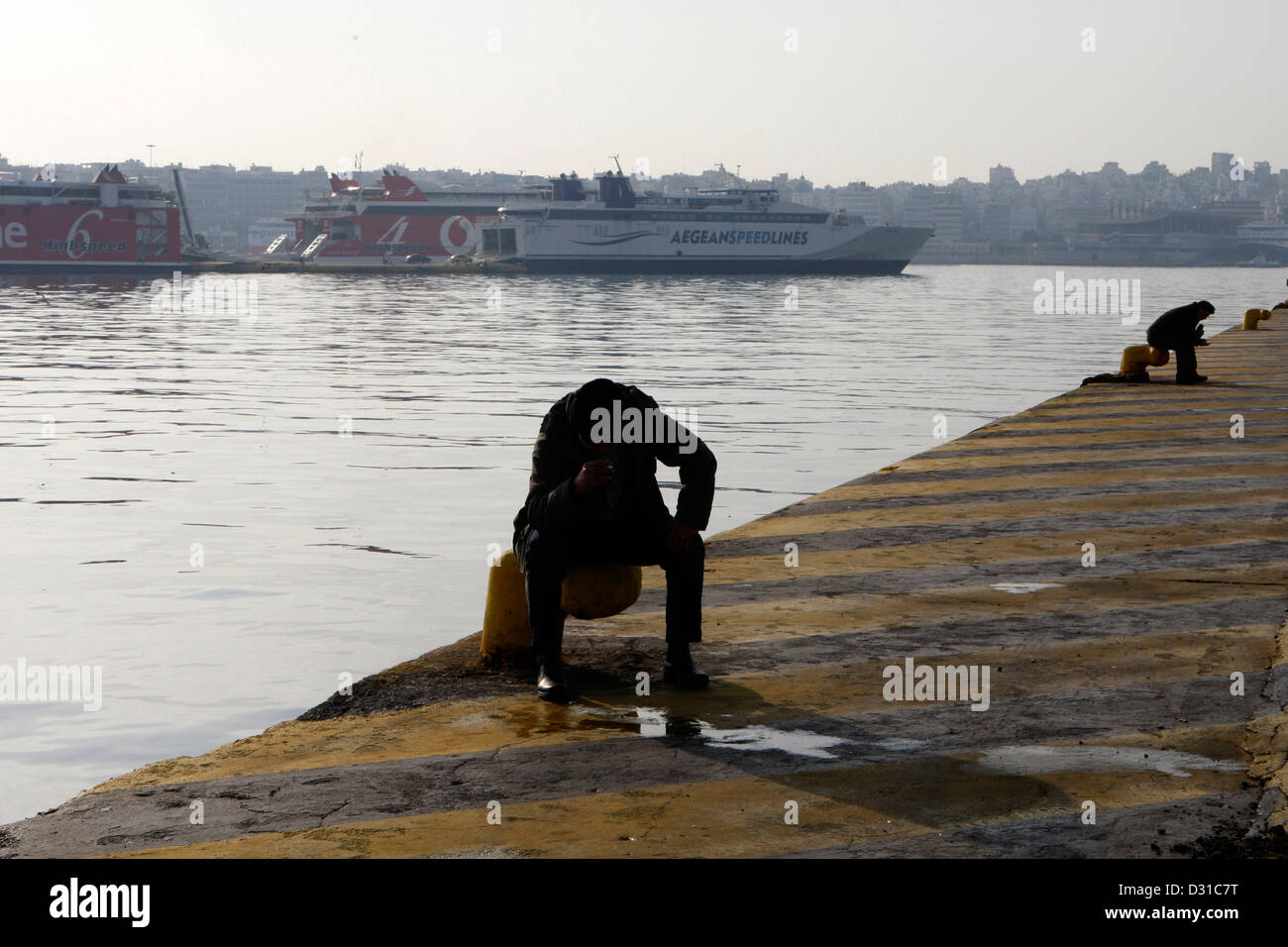 Men sit on a dock at Piraeus harbour Greece Stock Photo - Alamy