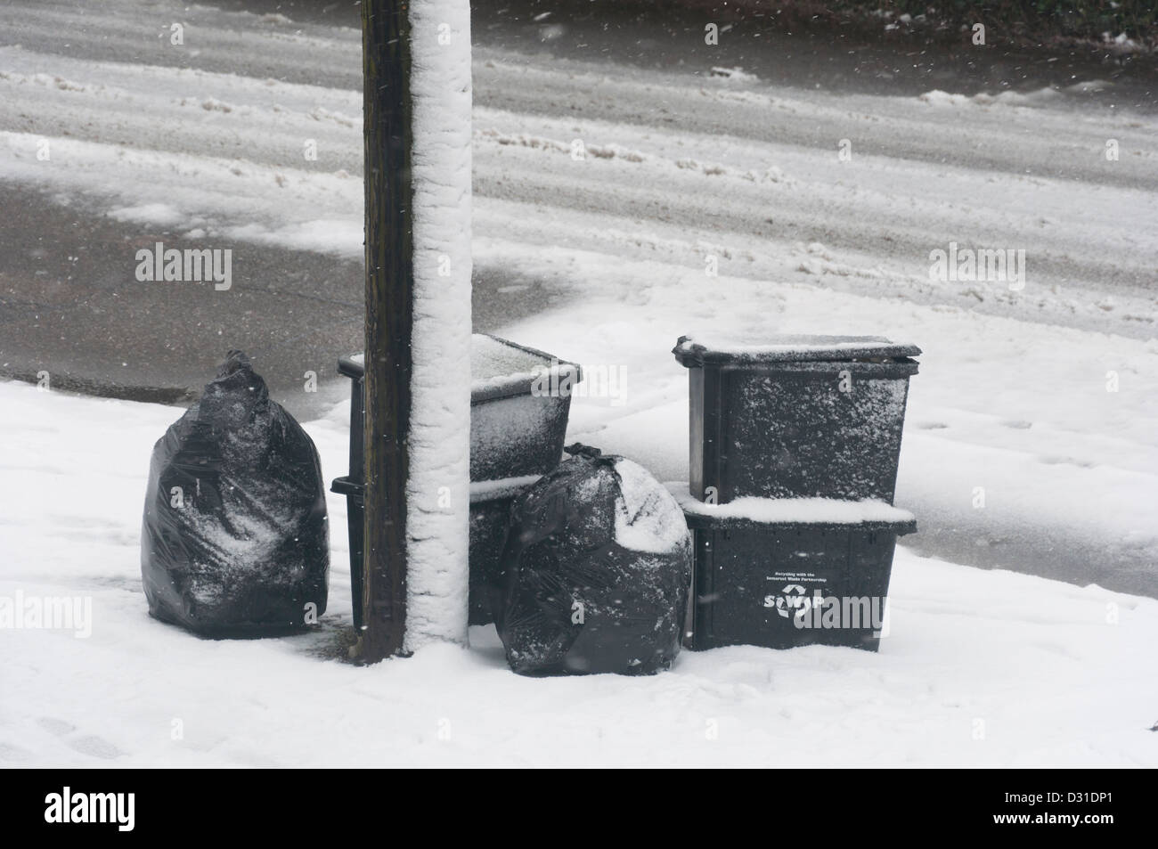 Rubbish and recycling awaiting collection in snowy winter conditions ...