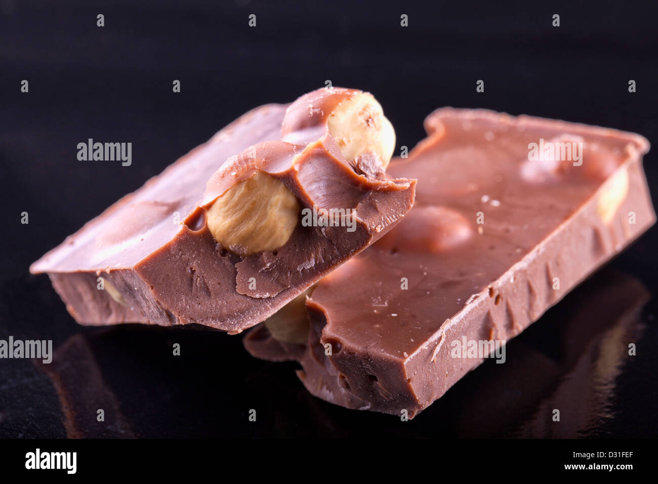 Two blocks of chocolate with nuts over black Stock Photo - Alamy