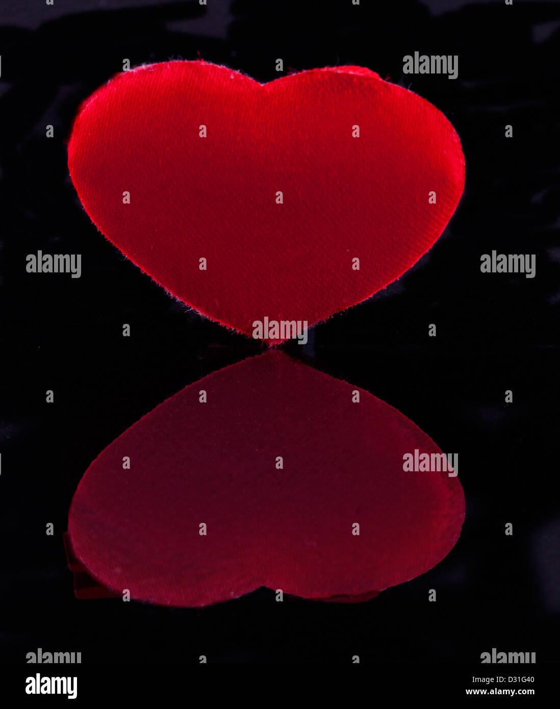Tissue red heart reflecting over black surface Stock Photo - Alamy