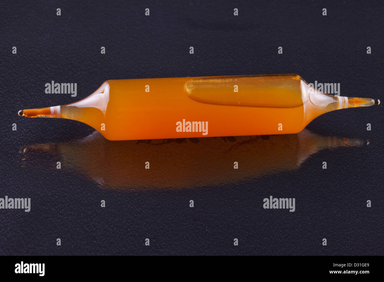 A Yellow vial over black reflecting surface Stock Photo - Alamy