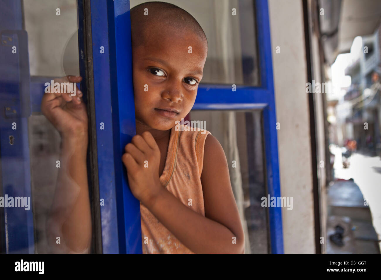 A young Indian child waits at a health clinic in Tehkhand Slum, Delhi ...