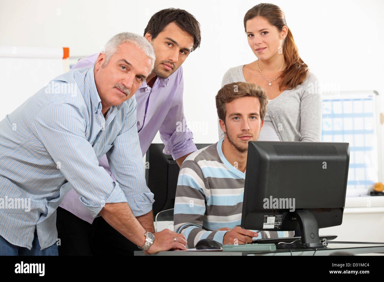 Teacher and students gathered around a computer screen Stock Photo - Alamy