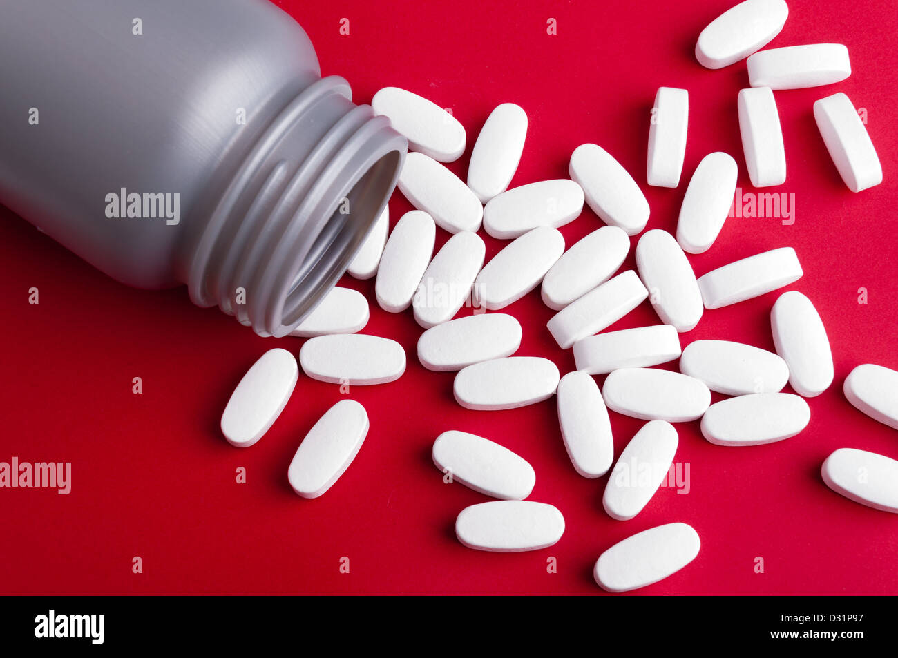 Close container of medicine in tablets on red background Stock Photo ...
