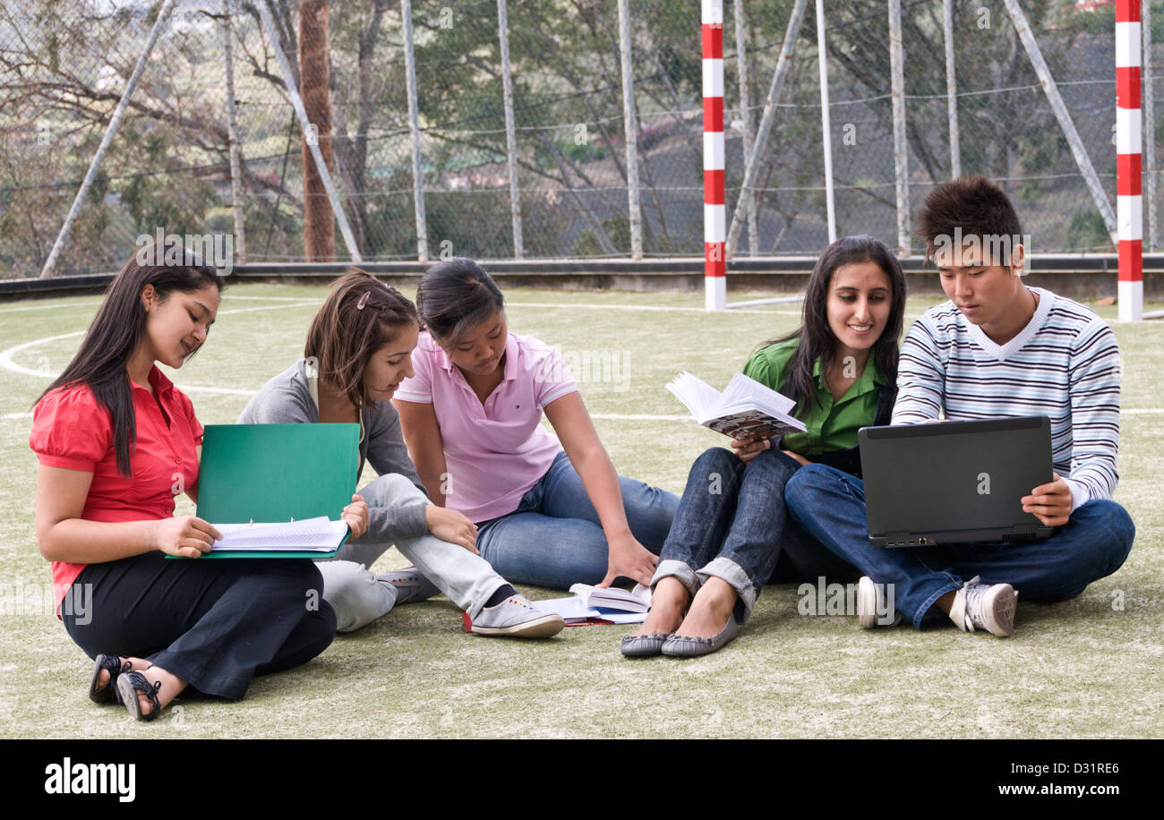 Group of senior teenage school students relax and talk together in an ...