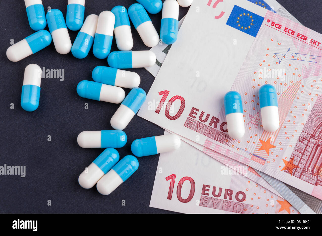 Pill drug and European currency on black background Stock Photo - Alamy
