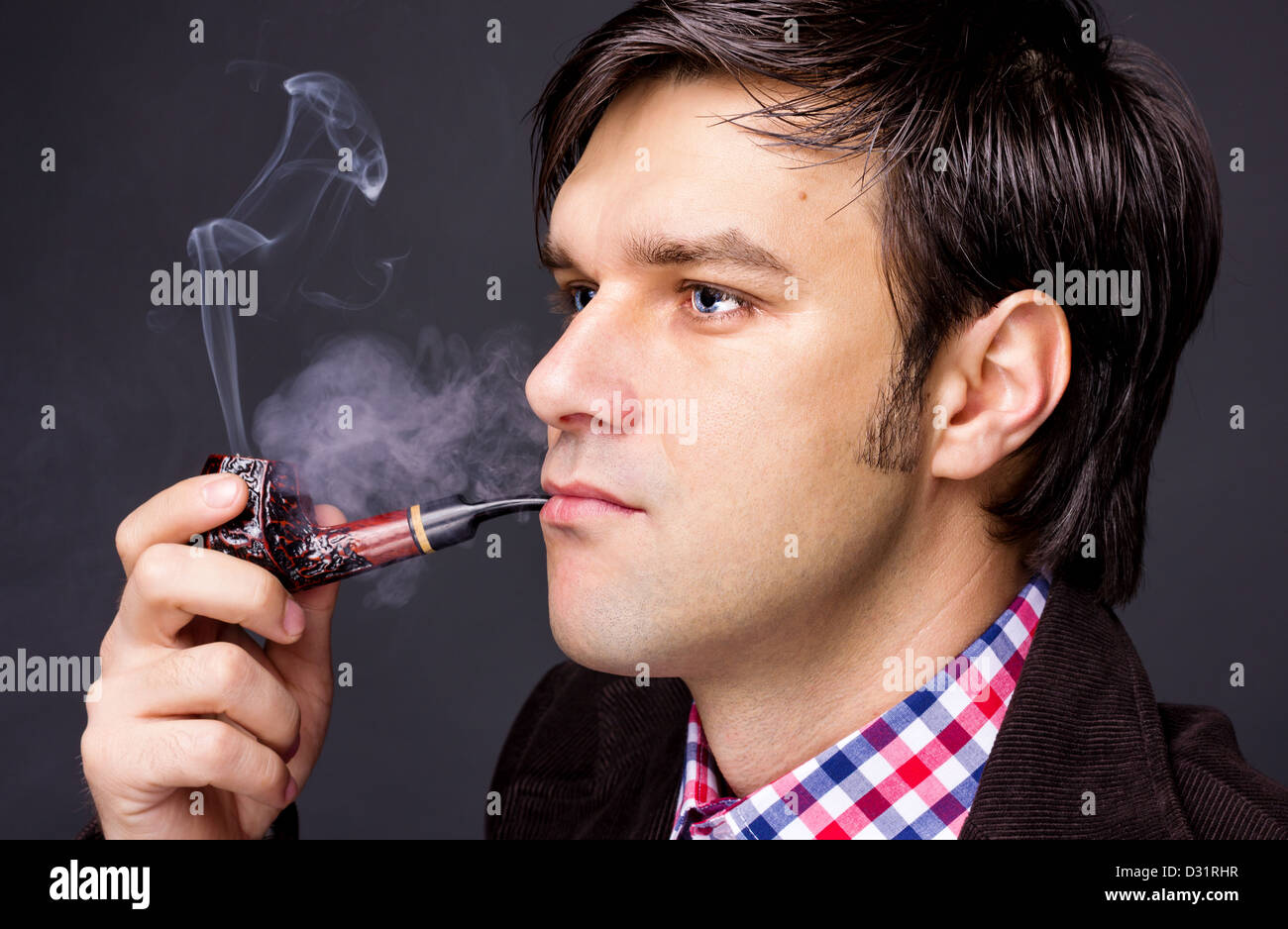 Closeup of a man smoking a pipe isolated on grey background Stock Photo ...