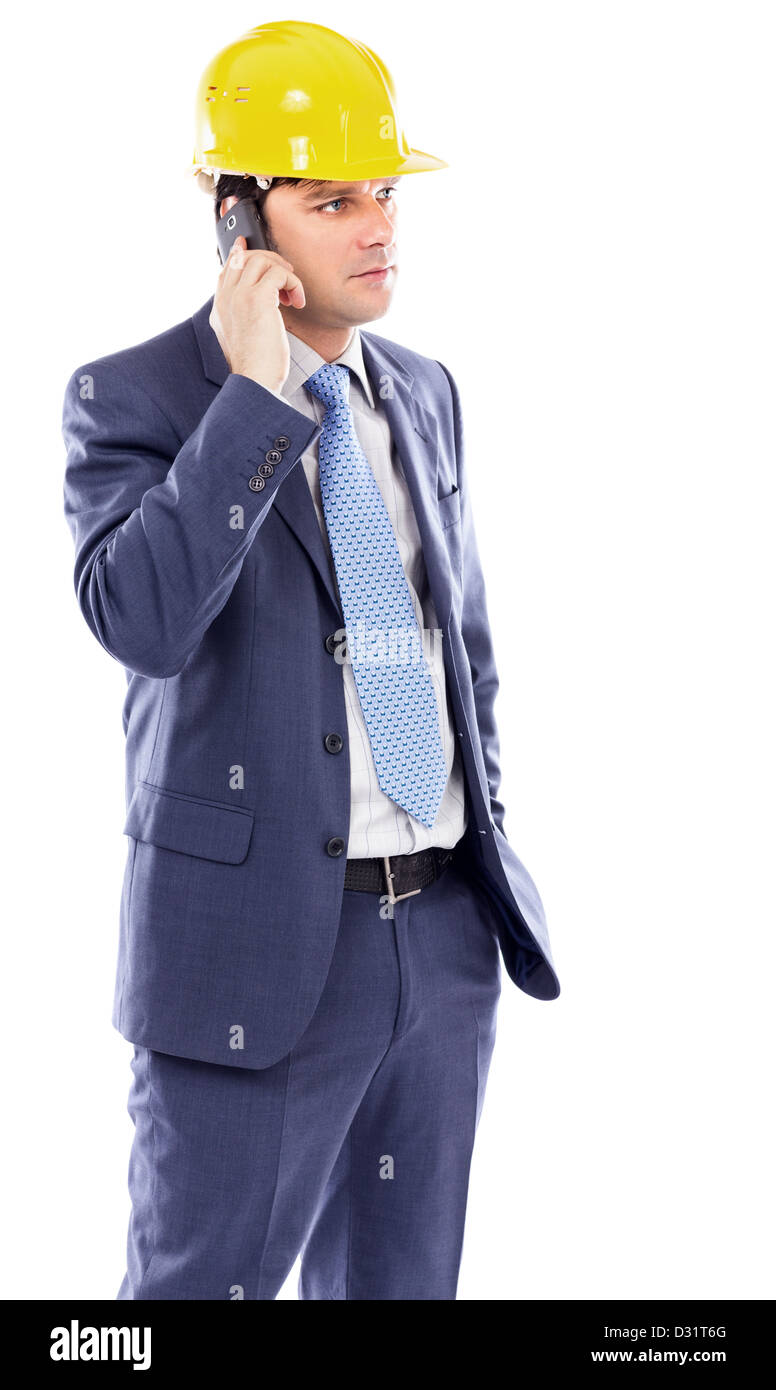 Portrait of a young engineer talking on the phone against white ...