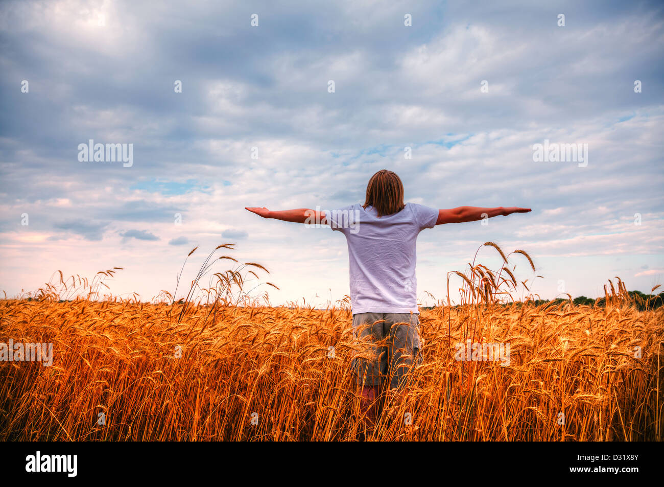 Young man staying with stretched out hands at sunset time Stock Photo ...