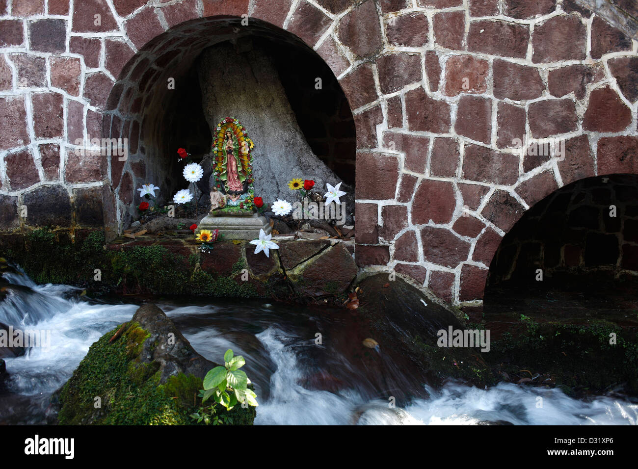 An altar to Our Lady of Guadalupe decorates a wall by the river of the ...