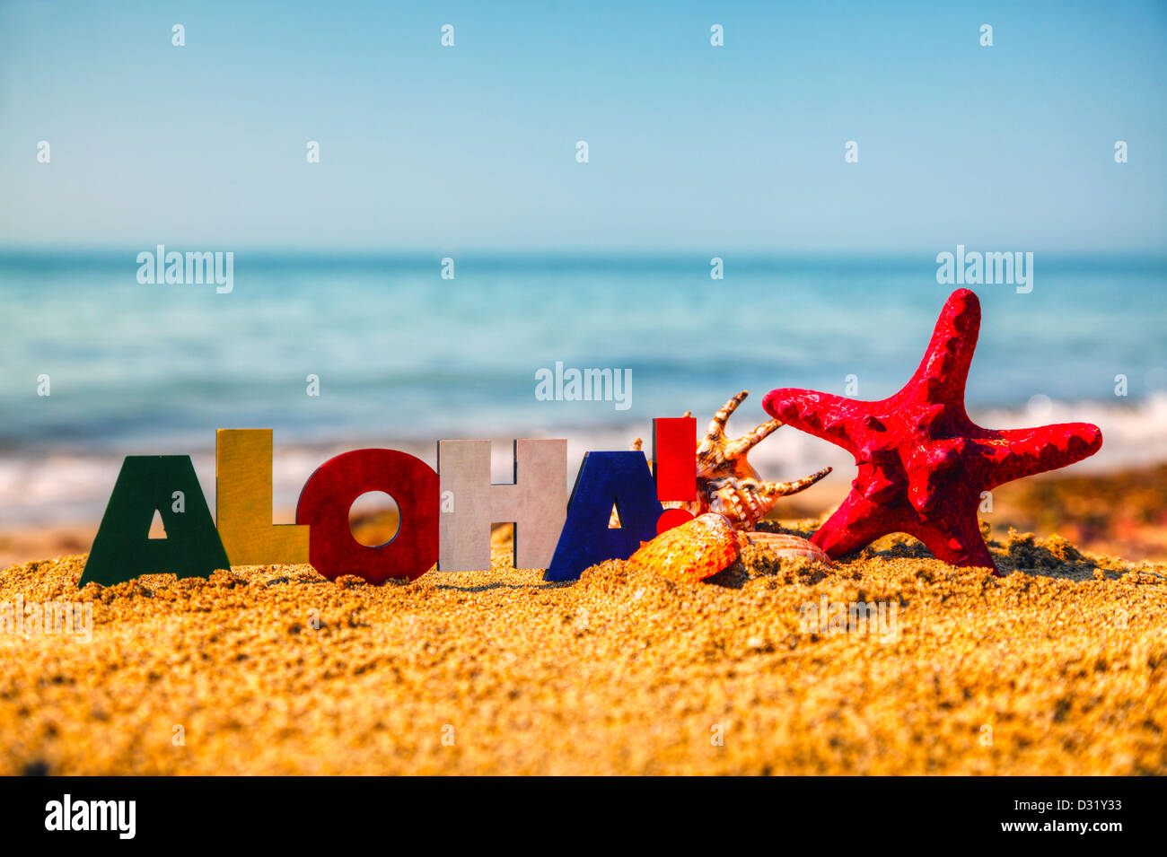 Wooden colorful word 'Aloha' with shells on the sand Stock Photo - Alamy